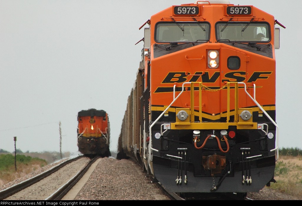 BNSF 5973, ES44AC, holds the siding while westbound empties pass by